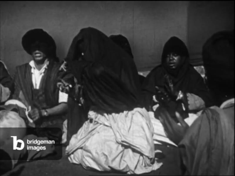 Image of Moroccan Berber men and women play drums, clap and sing,