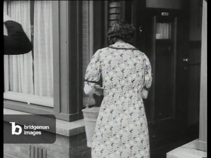 Image of Men from the air-raid protection hand out buckets with sand
