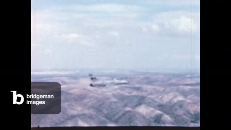 Image of Cold War supersonic jet fighter aircraft in flight over mountains