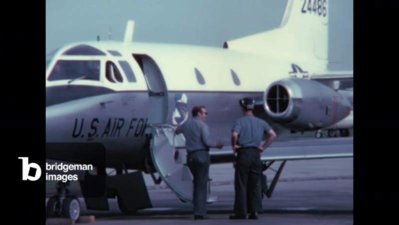Image of USAF officers talking near a parked VIP transport plane with